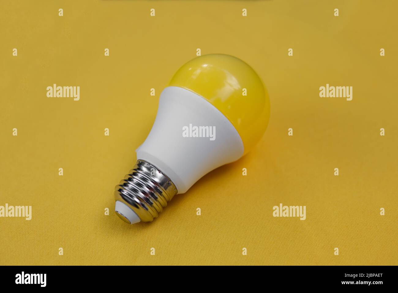 Yellow light bulb over yellow background Stock Photo - Alamy