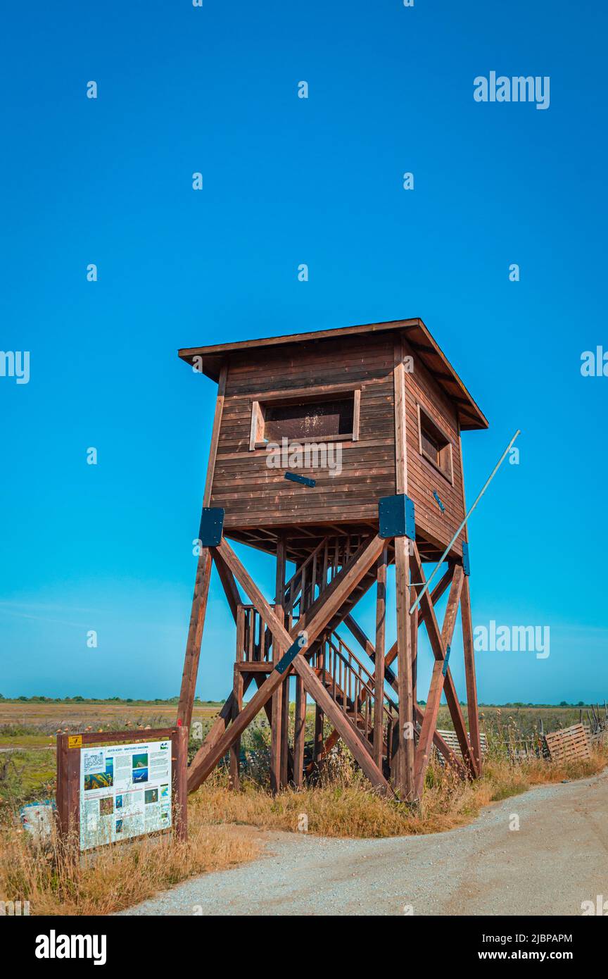 A wooden watchtower lookout tower on a field and a swamp created by the ...