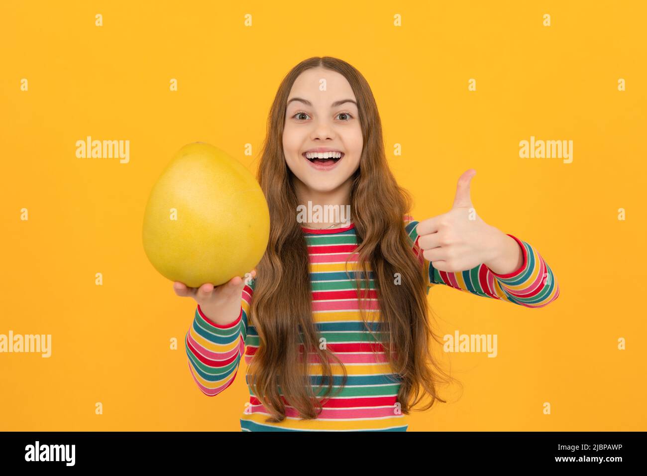 Summer fruits. Teenager child girl hold citrus fruit pummelo or pomelo ...