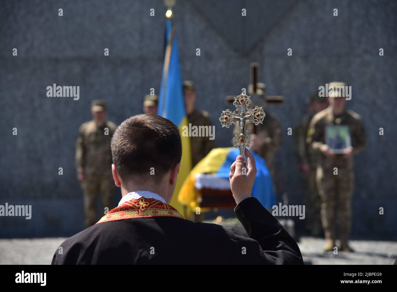 Lviv. Ukraine, 07 Jun 2022 A priest holds a cross during the farewell ceremony of the fallen ...