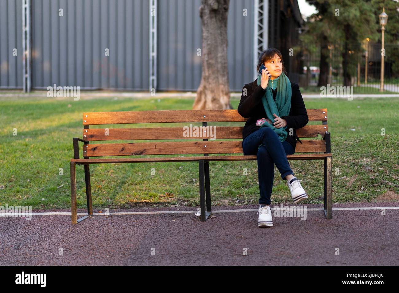 Woman in bench talking cell hi-res stock photography and images - Alamy