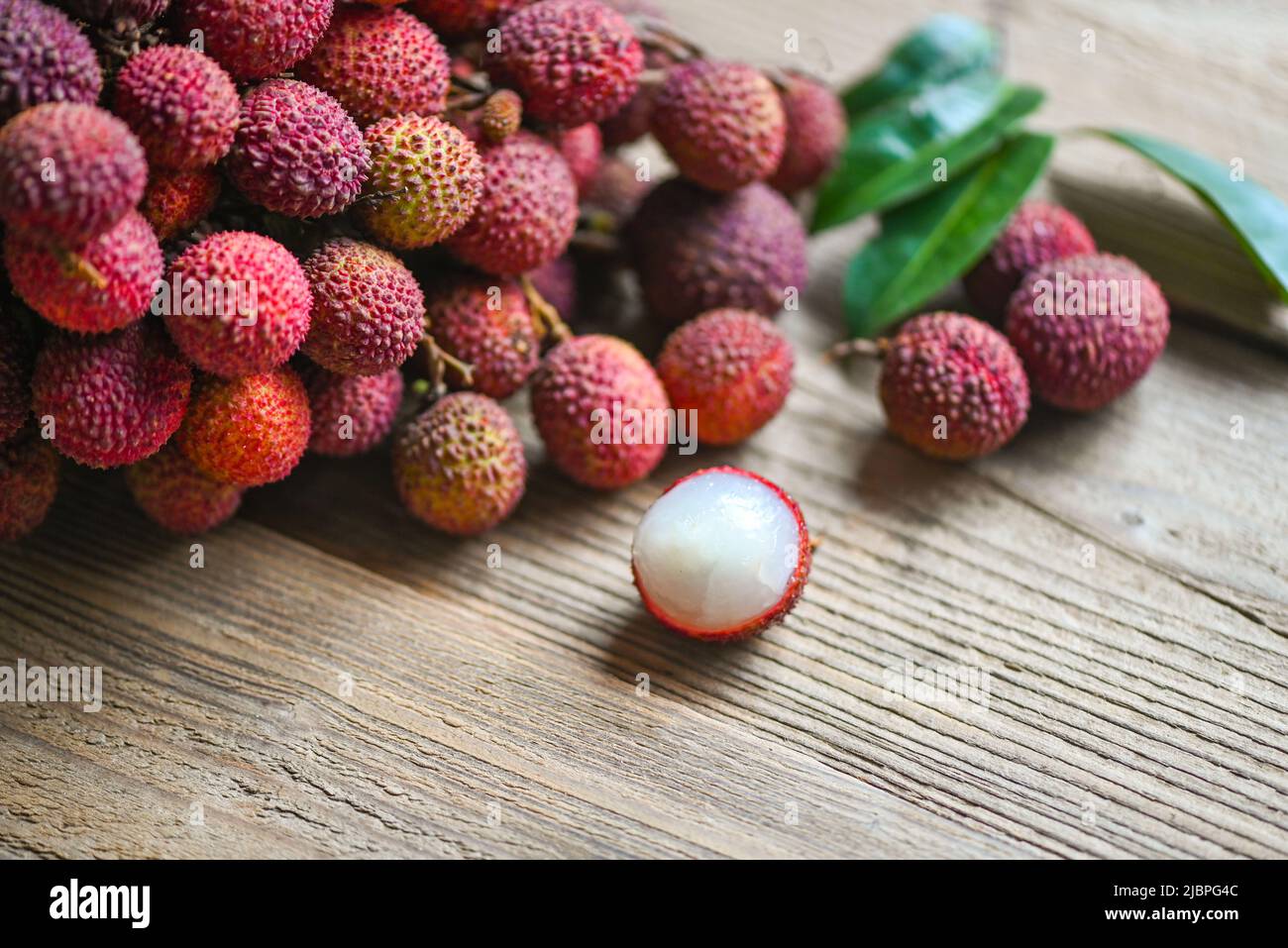 Lychee fruit on wooden background with green leaf , fresh ripe lychee ...