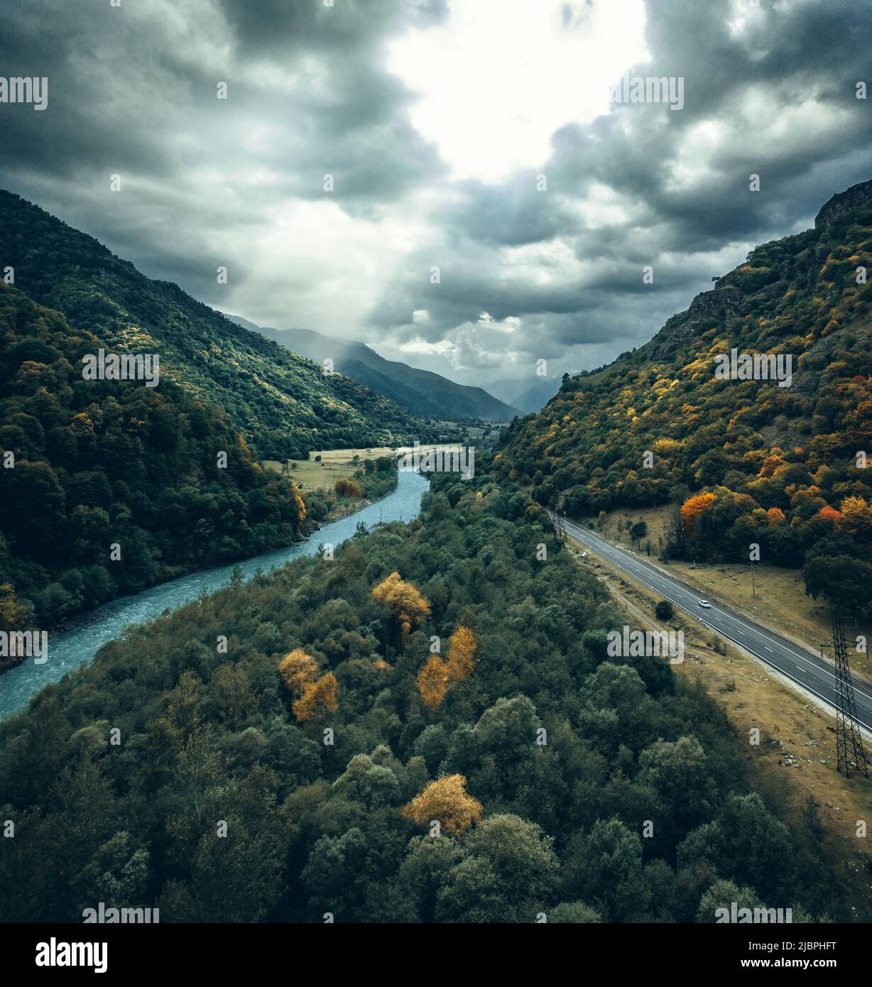 High angle aerial view of river and road running through forest and ...
