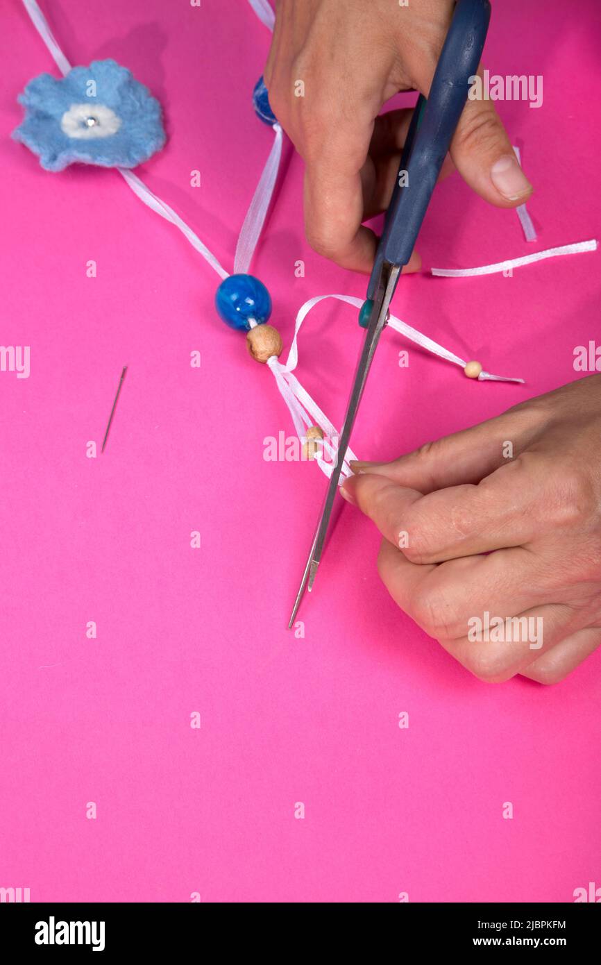 The female hands of the master assemble a handmade product from felted ...