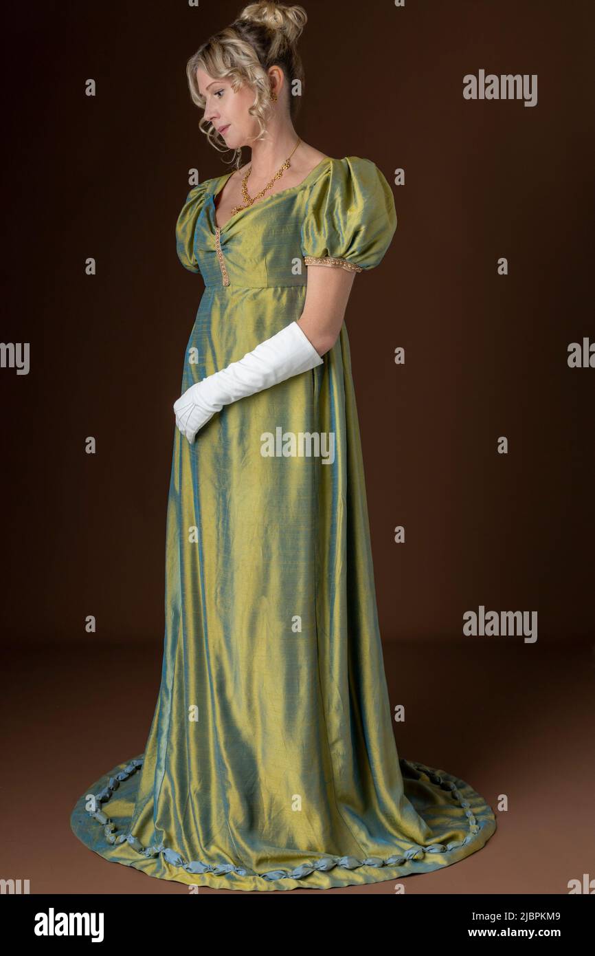 A Regency woman wearing a green shot silk dress and standing against a ...