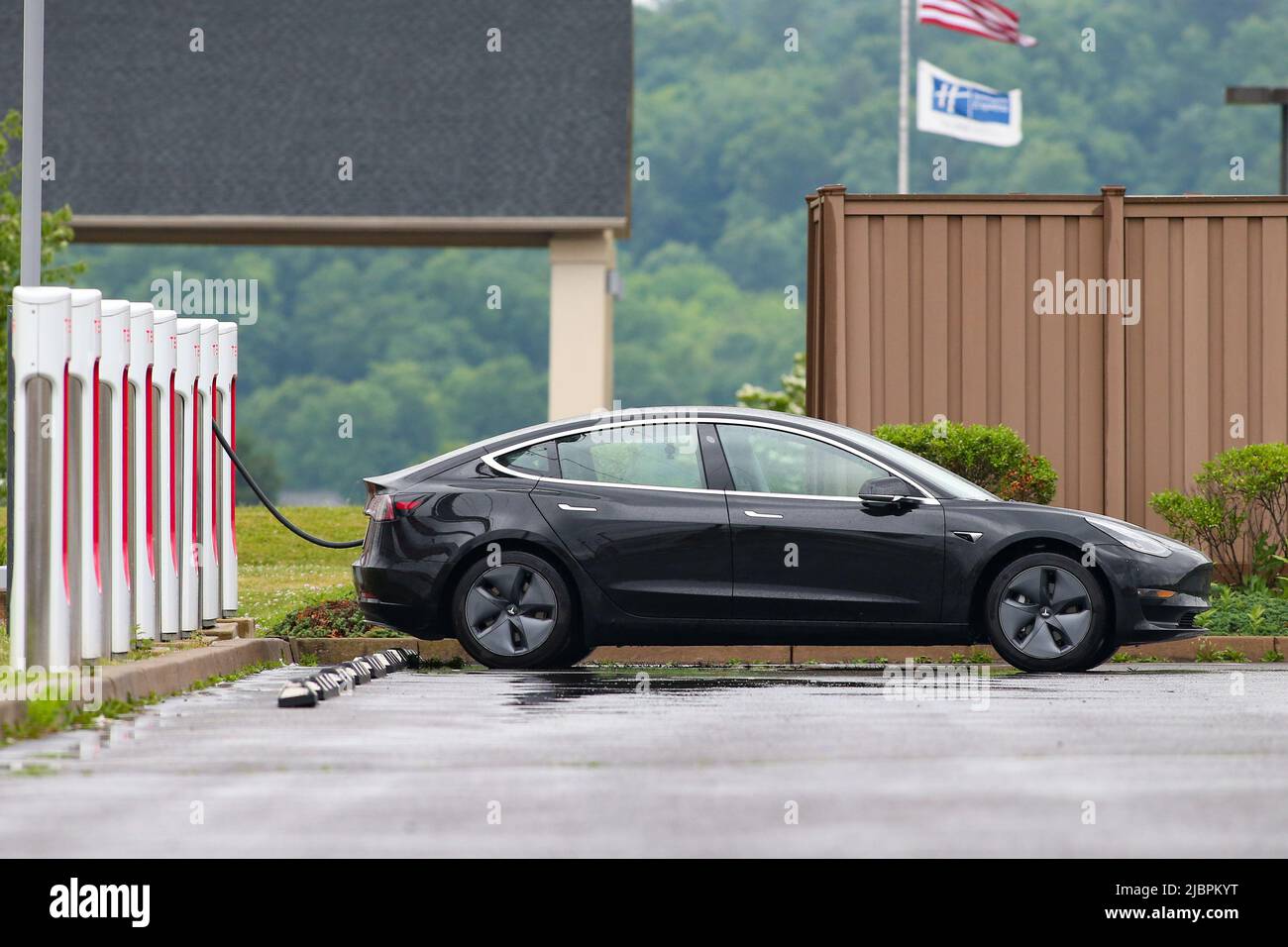 A Tesla electric vehicle is seen plugged in at a Tesla Supercharger ...