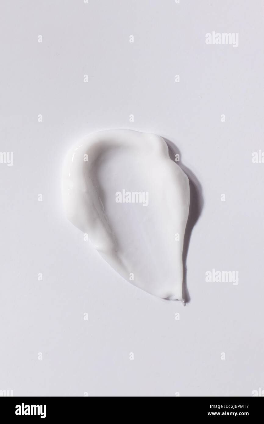 A smear of white skin cream on a white background. Cosmetic texture ...
