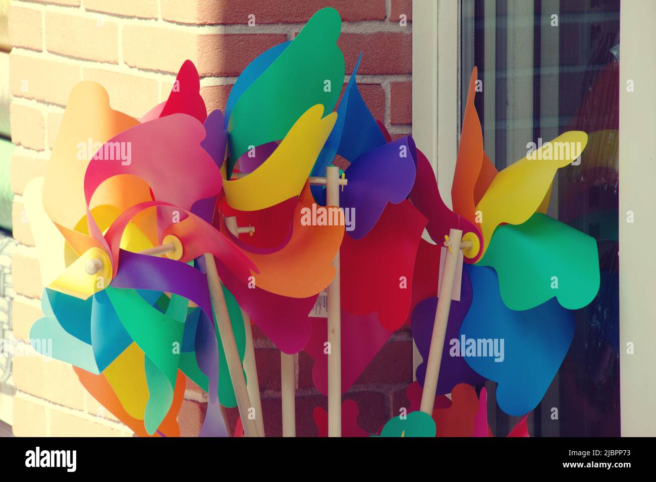 Windmill toys with a brick background Stock Photo - Alamy