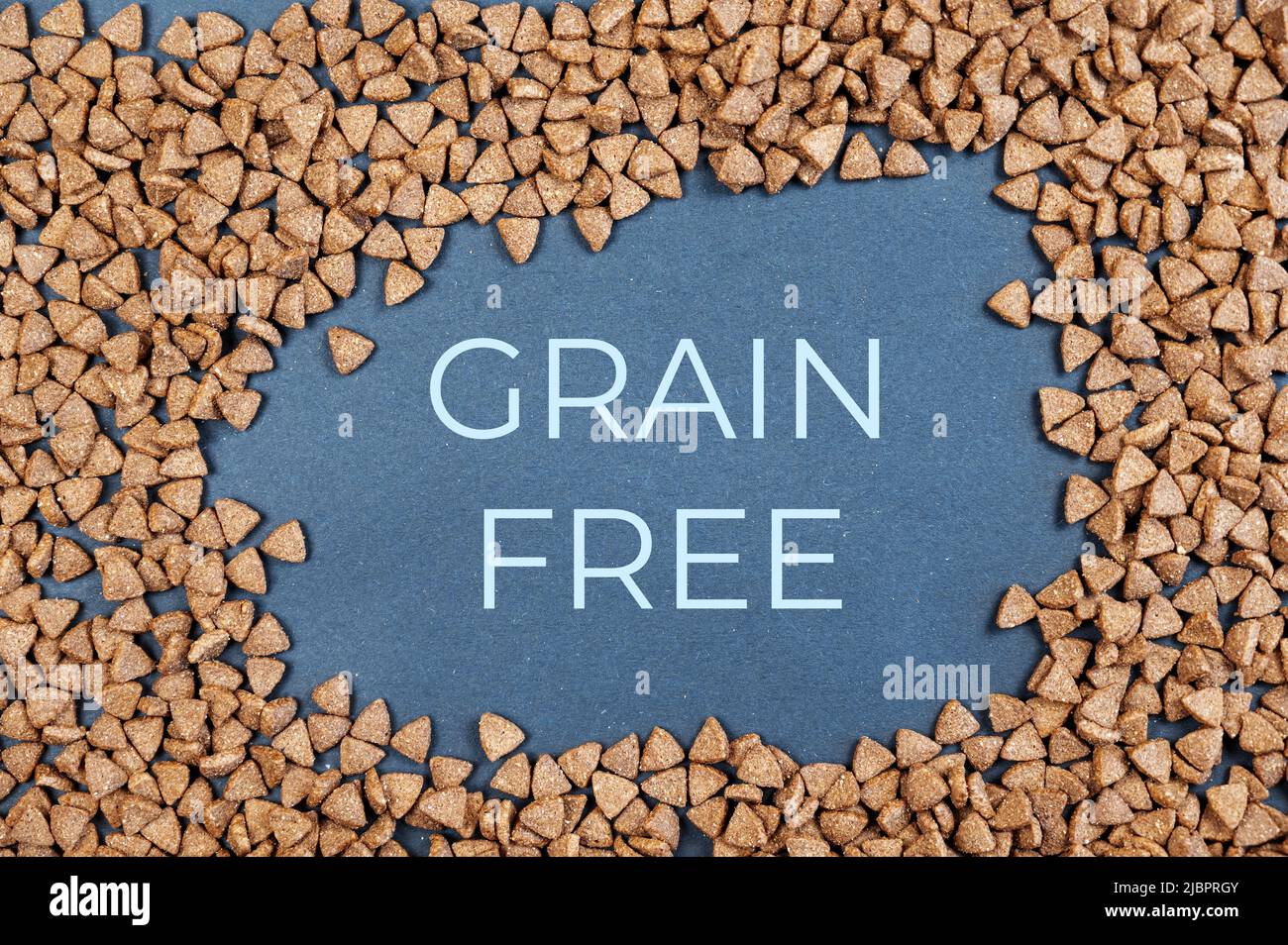 Dry cat food against a gray background. Pellets are triangular. Grain ...