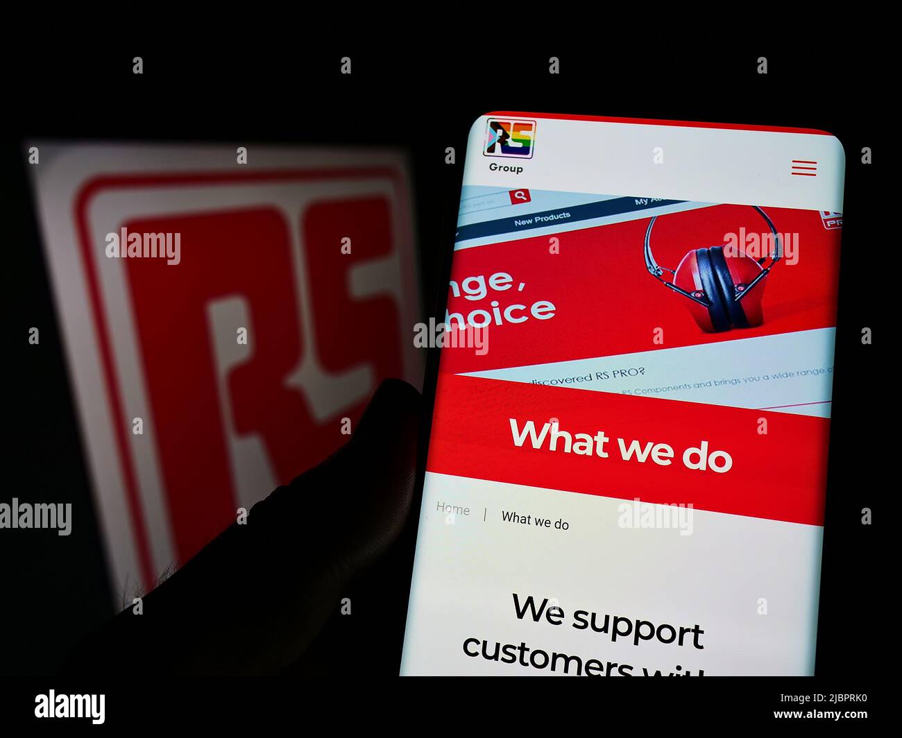 Person holding cellphone with webpage of British electronics company RS ...