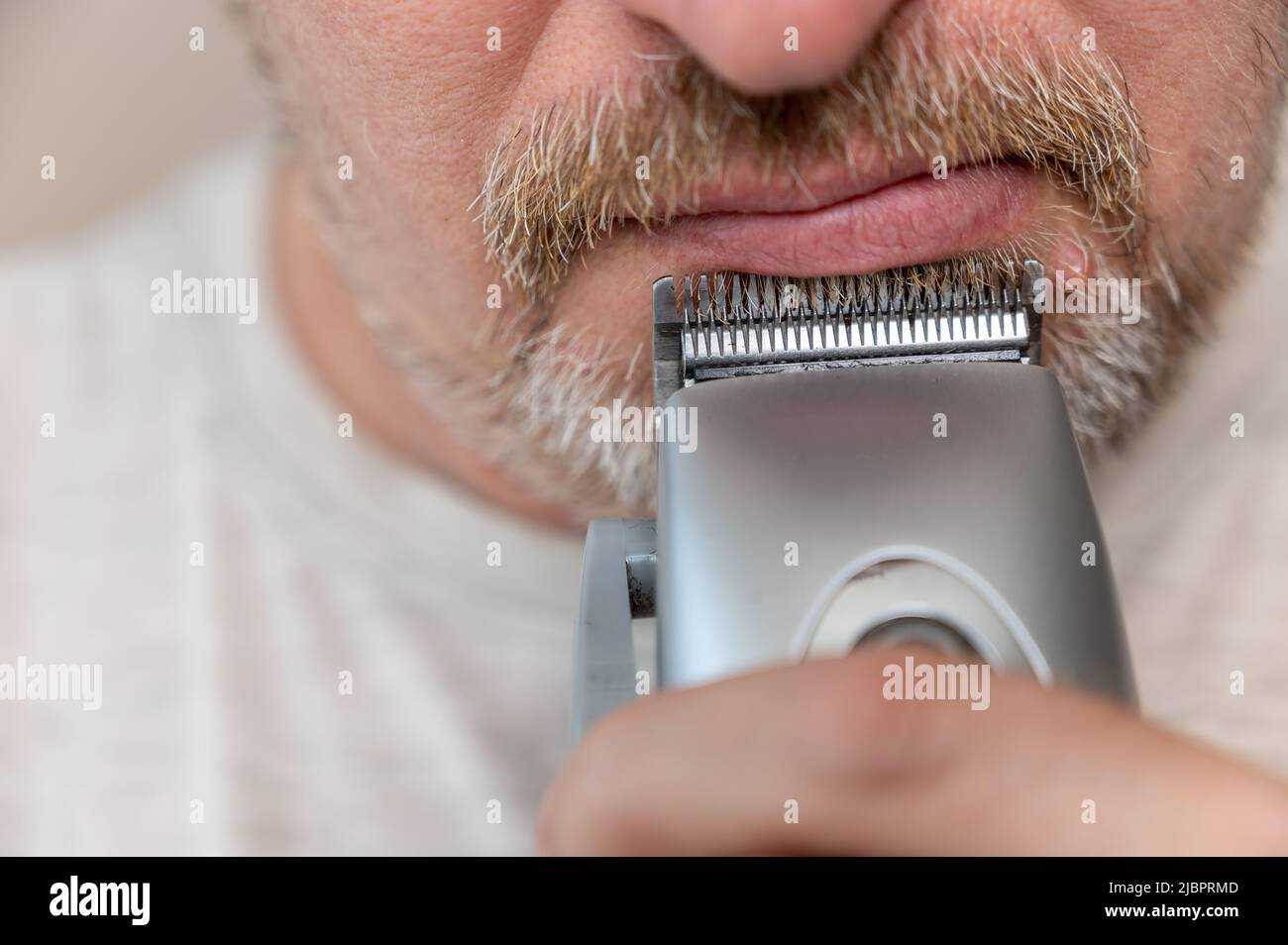 A mature man shaving. The bottom of a man's face. Man cuts facial hair ...