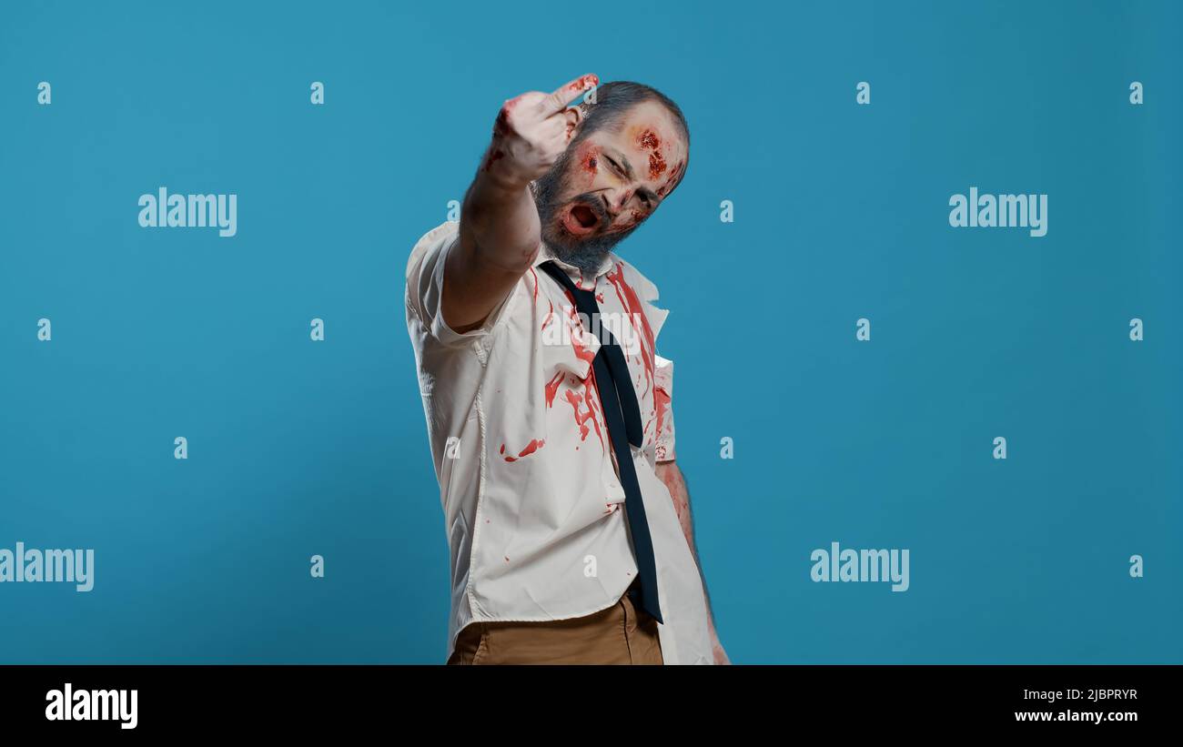 Evil looking scary mindless zombie being rude by showing middle finger ...
