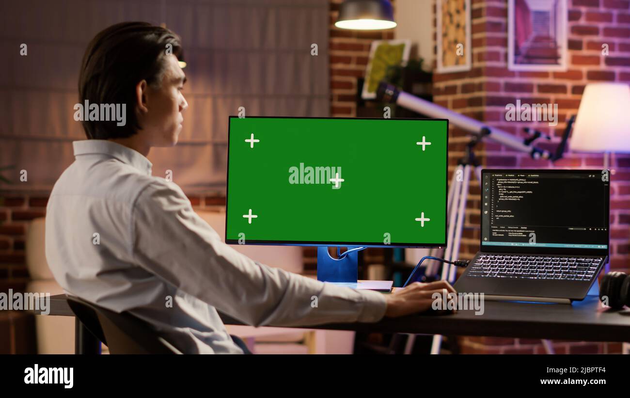 Male entrepreneur using computer display with greenscreen to work on ...