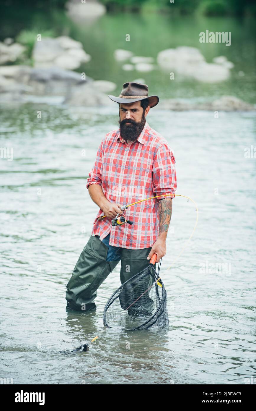Fisherman caught a fish. Man fishing on river Stock Photo - Alamy
