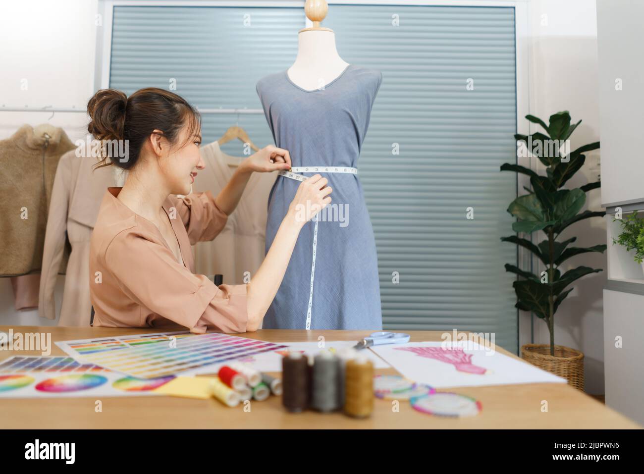 Fashion design concept, Asian female designer use tape measure to ...