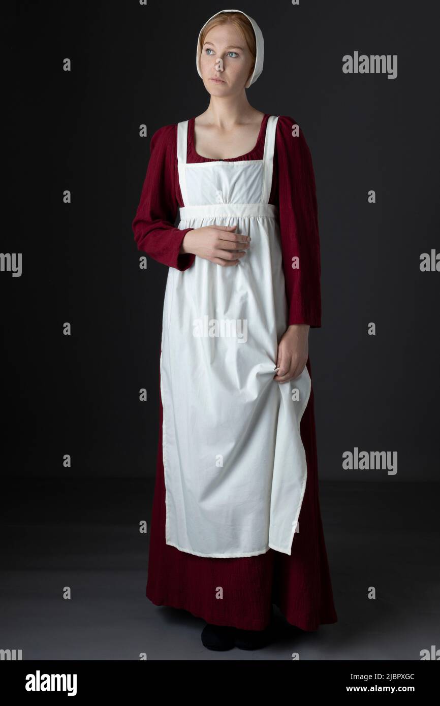 A Regency serving maid wearing a red dress and an apron Stock Photo - Alamy