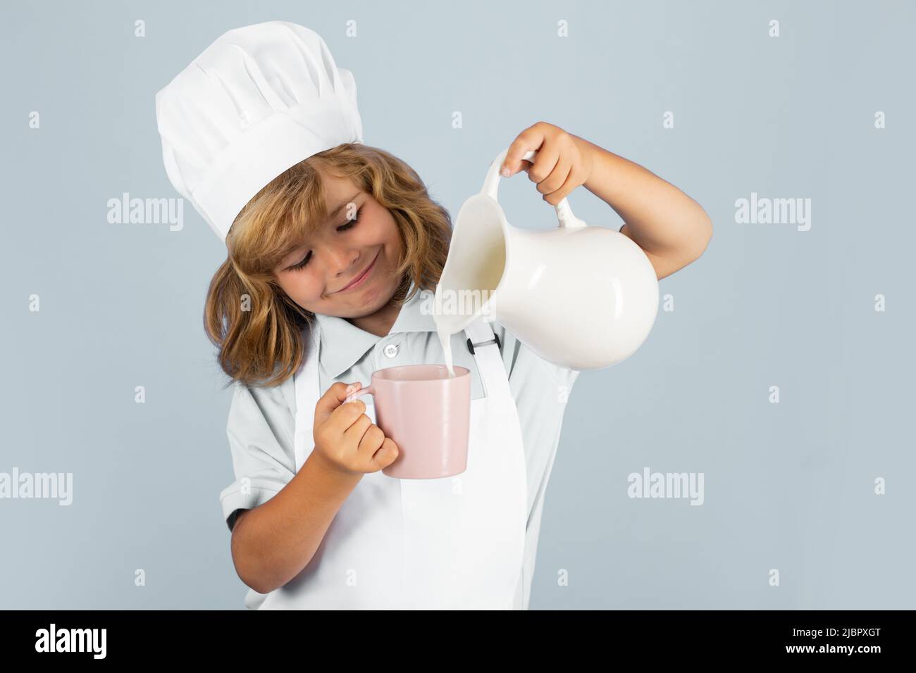 Milk for children. Child chef dressed cook baker apron and chef hat ...