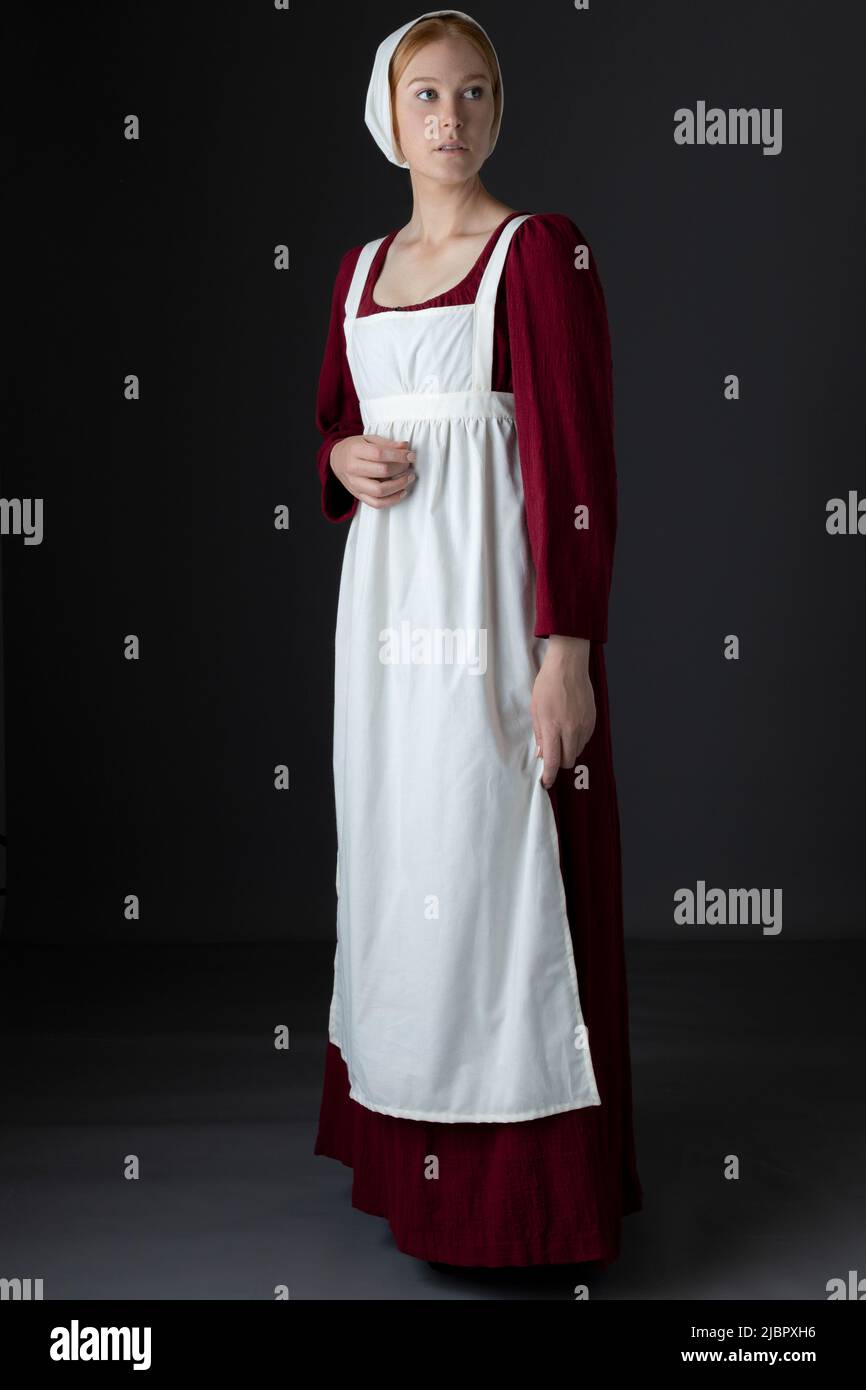 A Regency serving maid wearing a red dress and an apron Stock Photo - Alamy