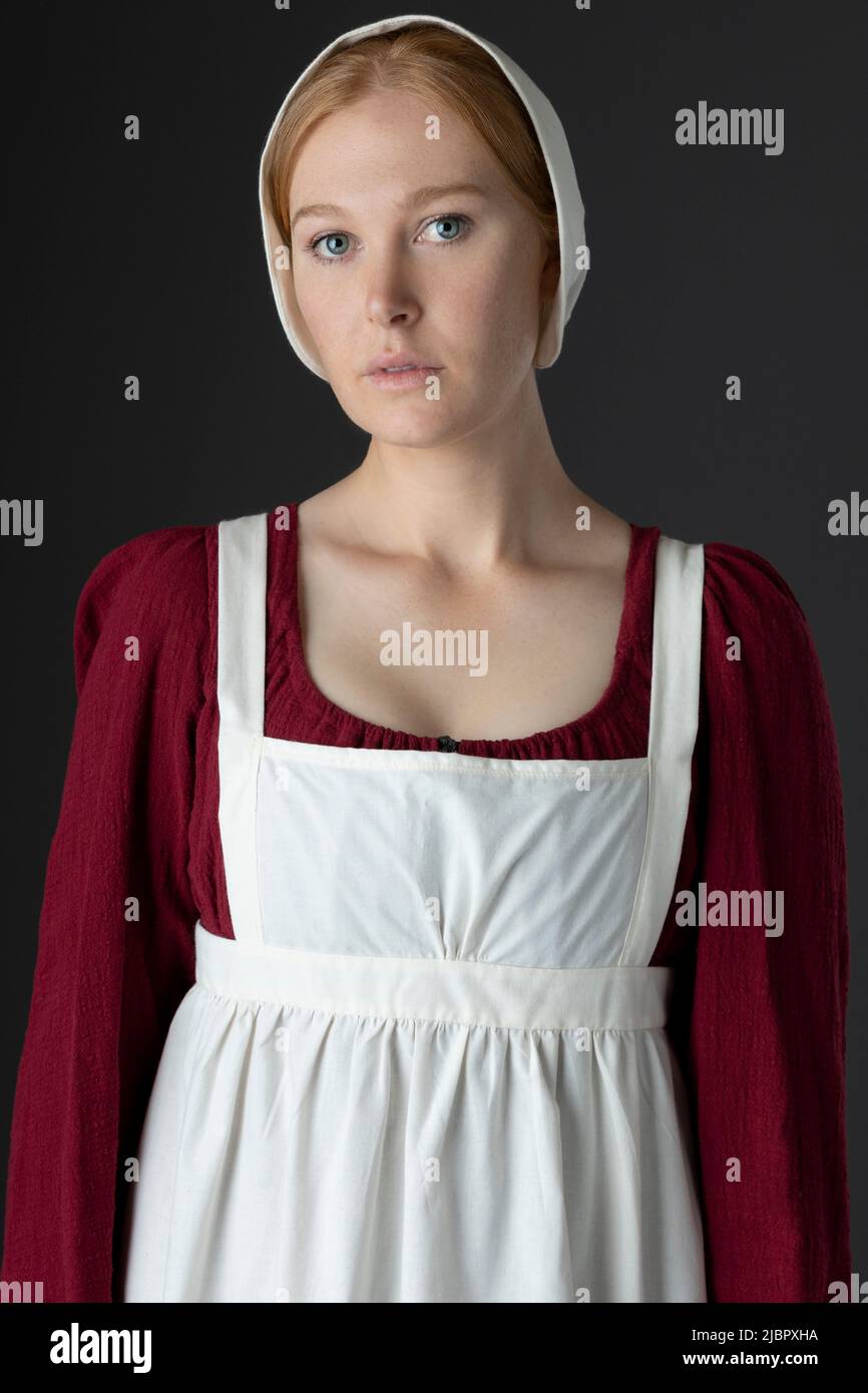 A Regency serving maid wearing a red dress and an apron Stock Photo - Alamy