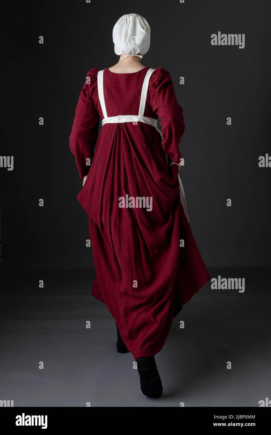 A Regency serving maid wearing a red dress and an apron Stock Photo - Alamy