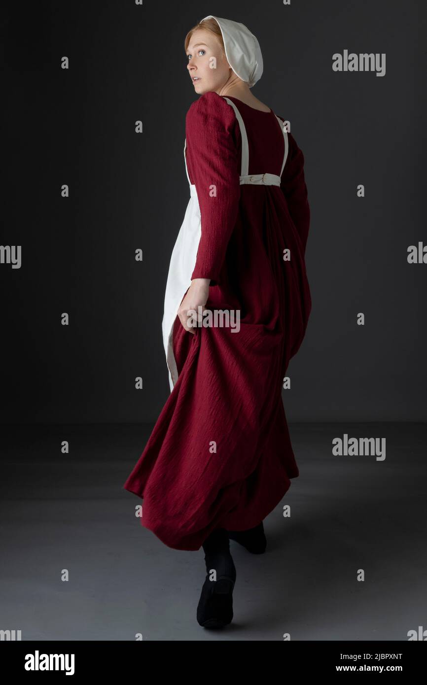 A Regency serving maid wearing a red dress and an apron Stock Photo - Alamy