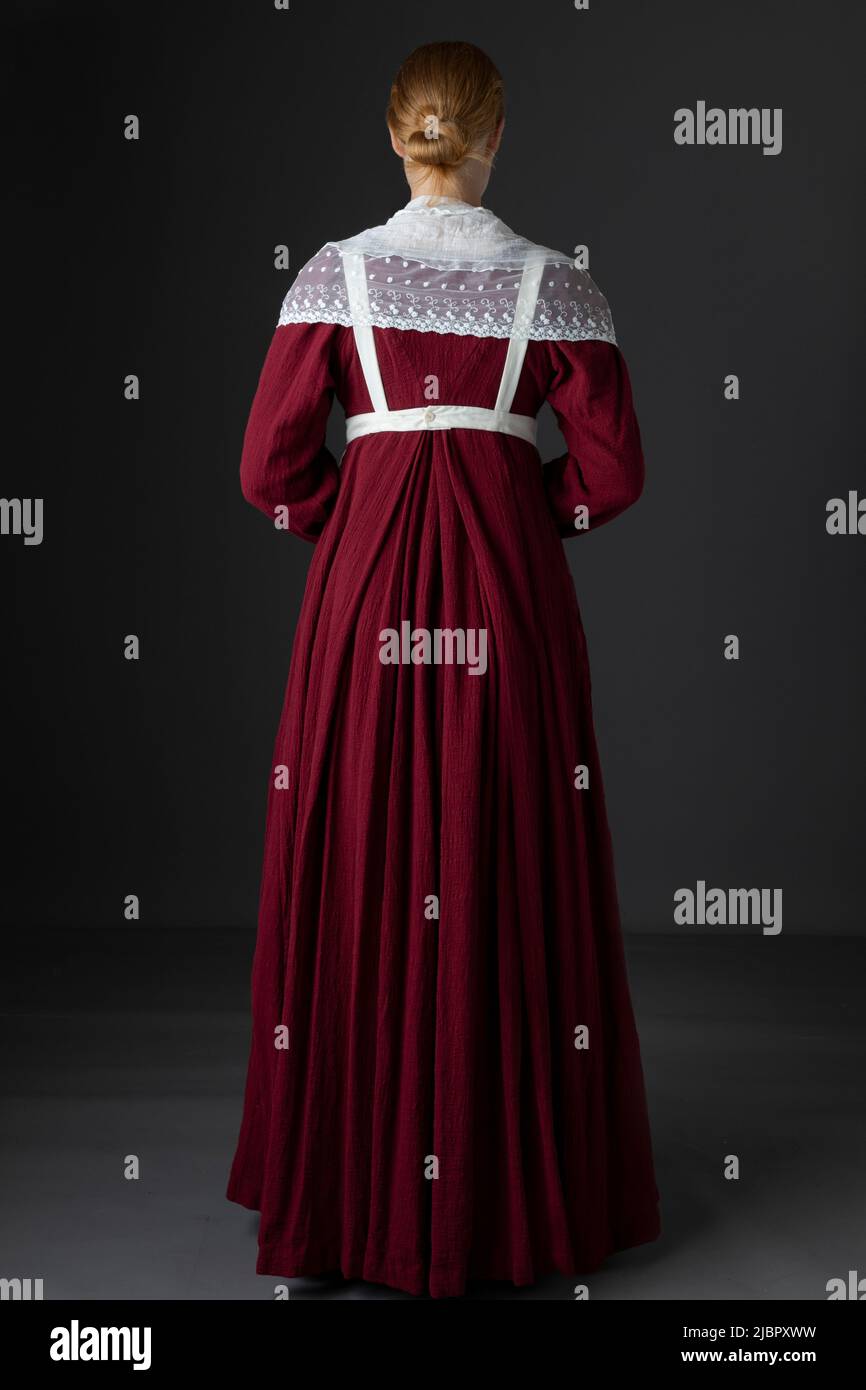 A Regency serving maid wearing a red dress and an apron Stock Photo - Alamy
