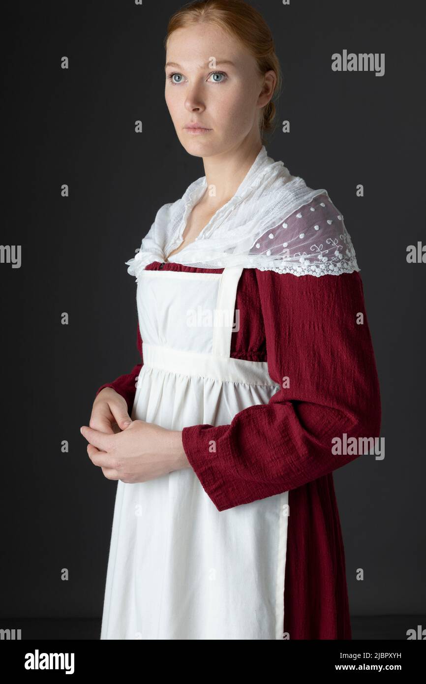 A Regency serving maid wearing a red dress and an apron Stock Photo - Alamy