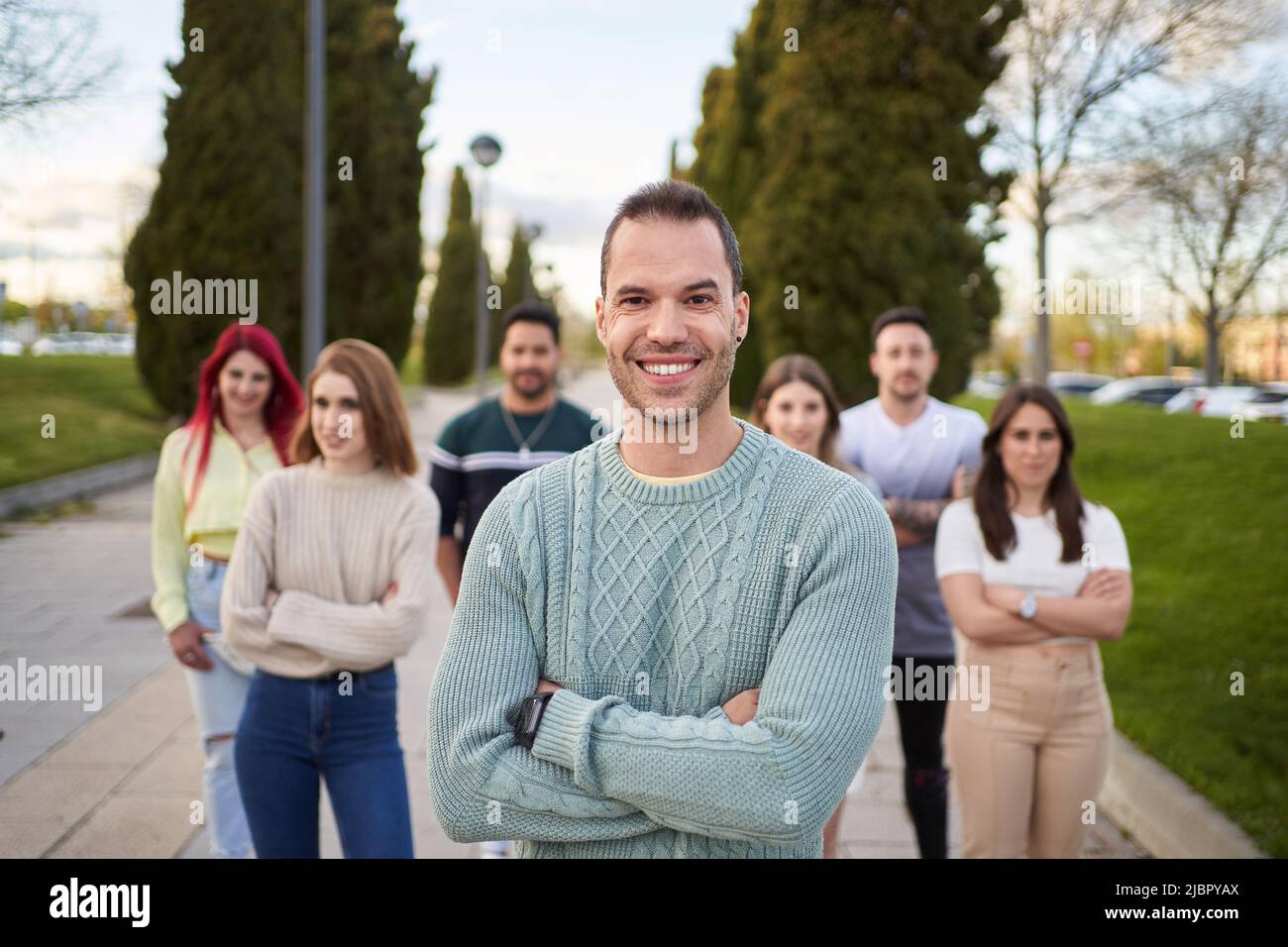 Man smiling looking at the camera while standing in front of a group of ...