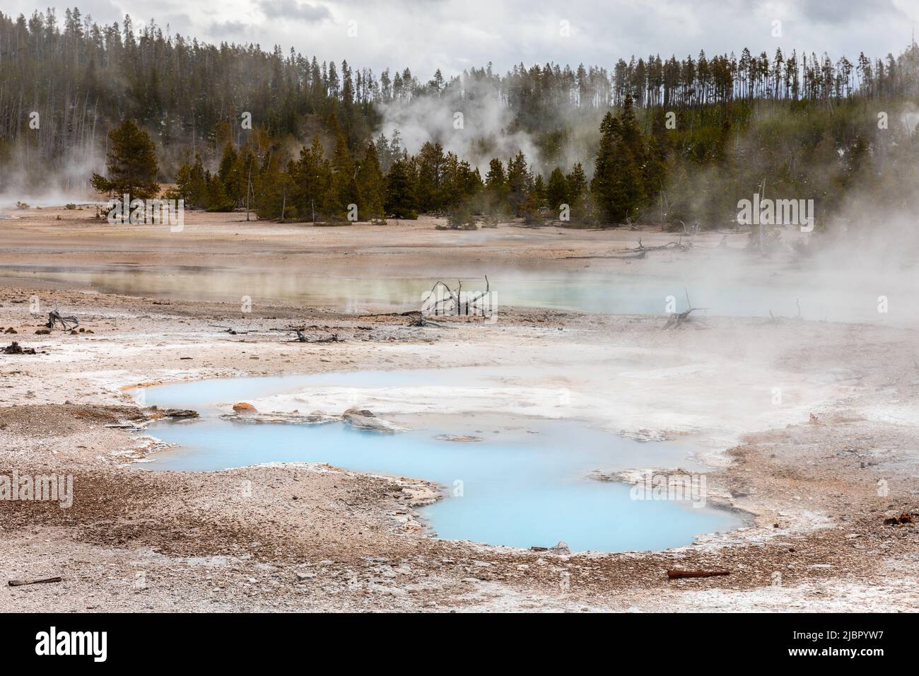Landscape of boiling water of blue geyser basin with smoke and ...