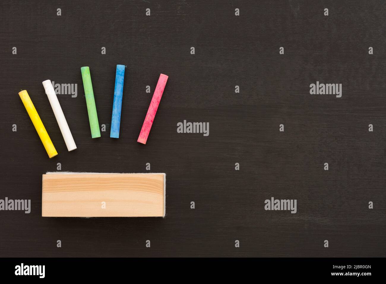 Top view, empty chalkboard with colored chalk and eraser. Space for ...