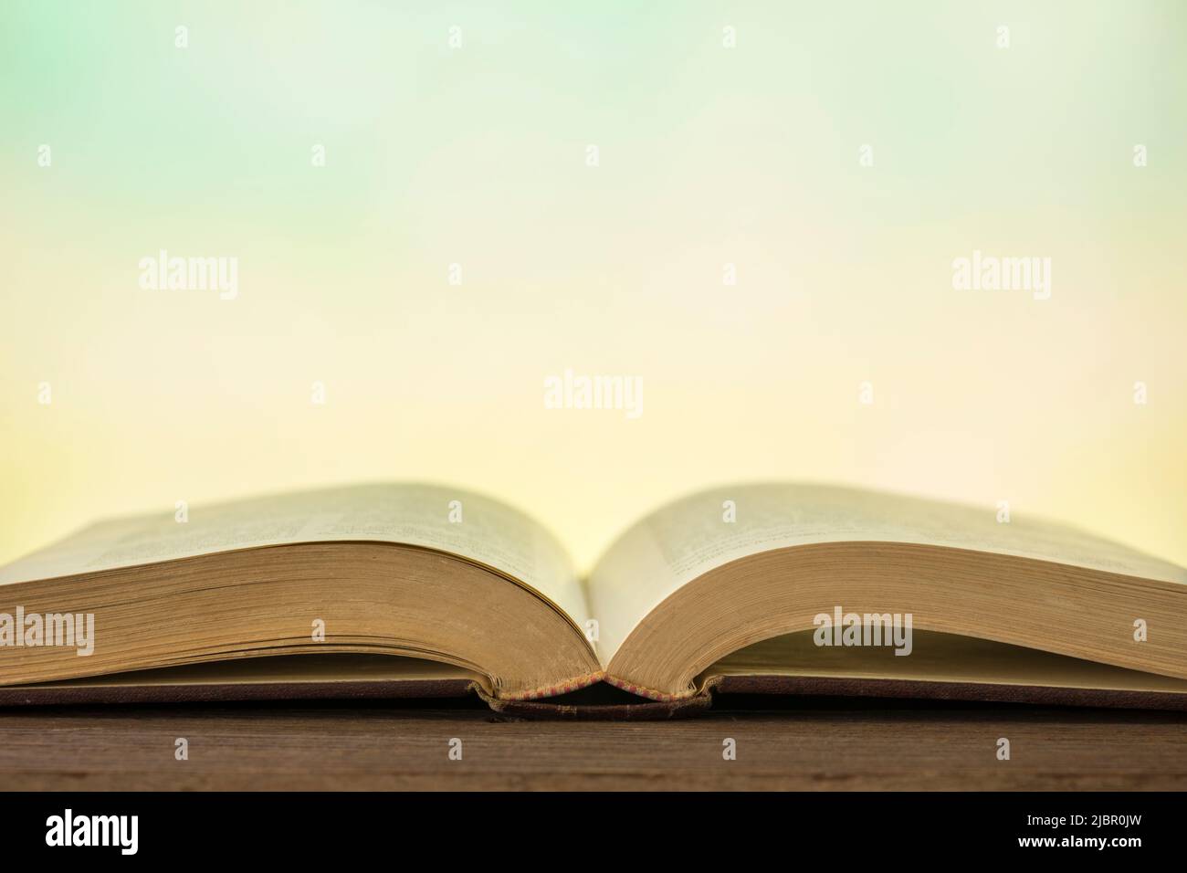Open book on wood table with abstract light background Stock Photo - Alamy