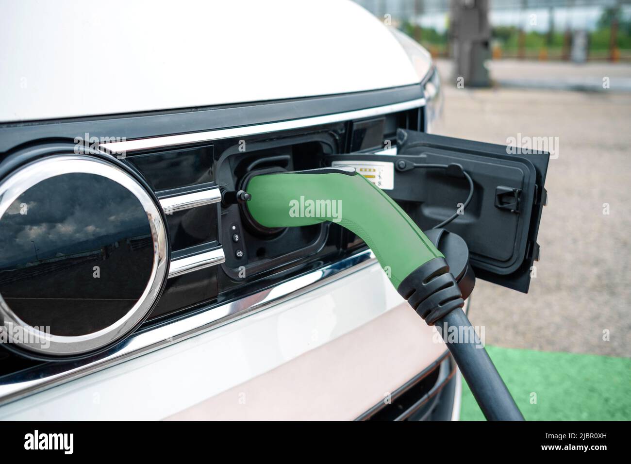 Detail of socket plugged into electric car Stock Photo - Alamy