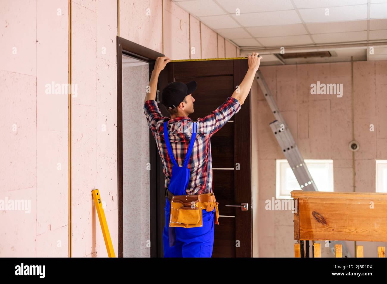 Carpenter worker installation process of measures cloth with ruler door ...
