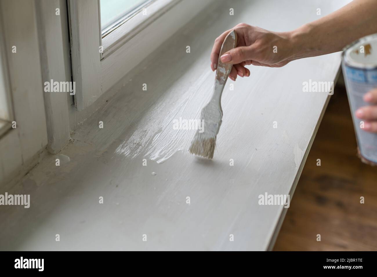 Worker painting frame of old window, painting old windows in white ...