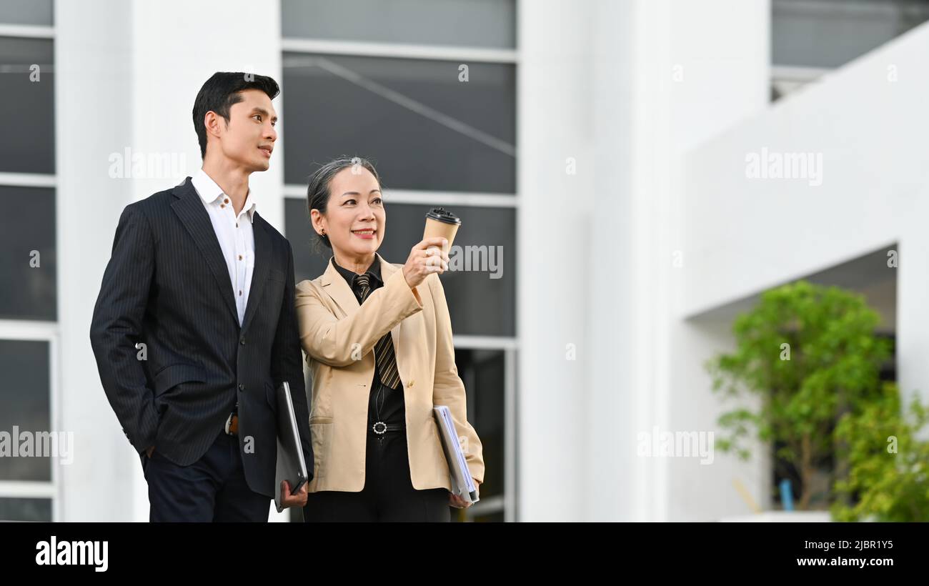 Two business people in formal suit, talking and discussing their jobs ...