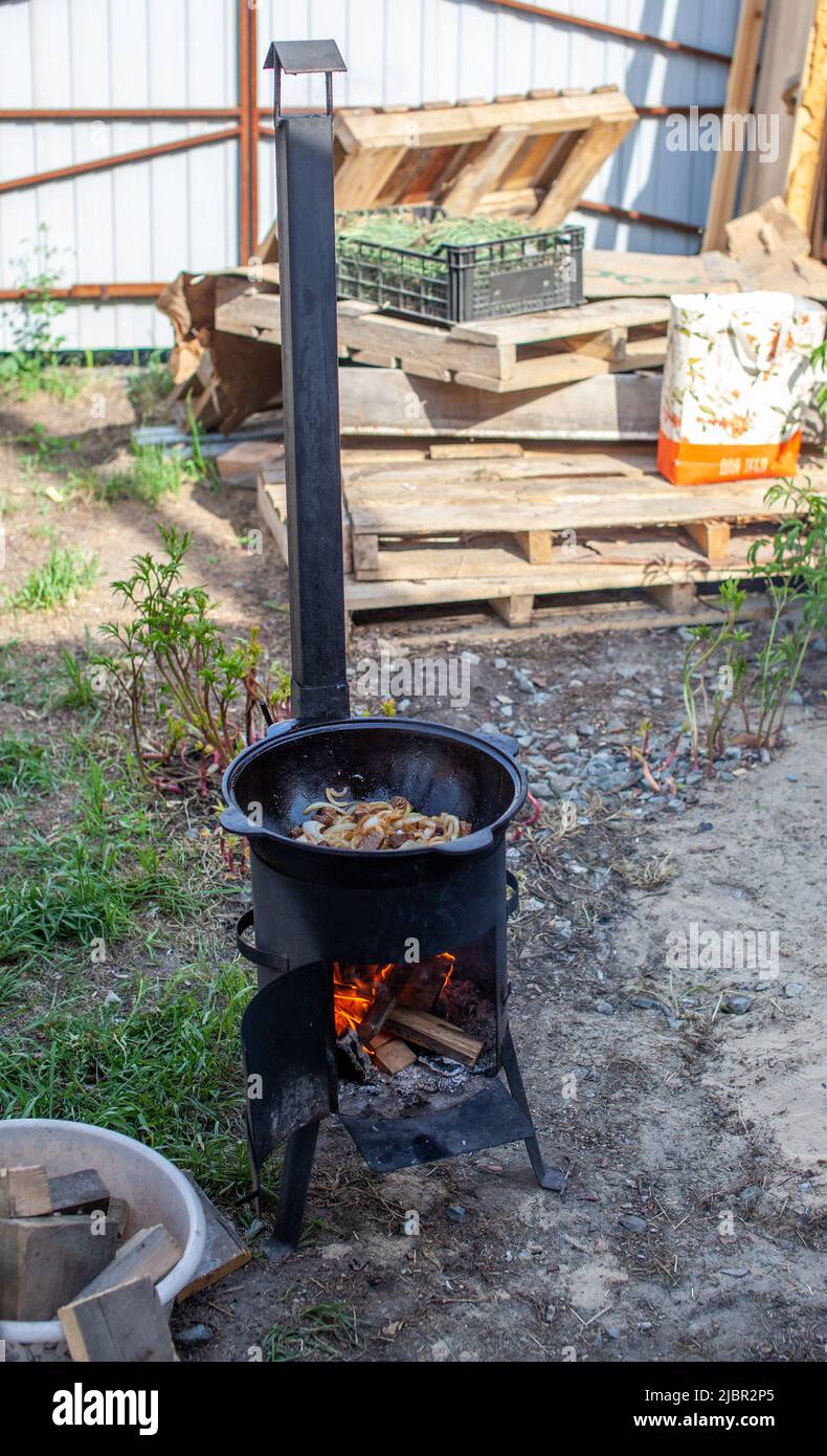 Cooking food or pilaf in a cauldron on fire. Cooking in cauldron on ...