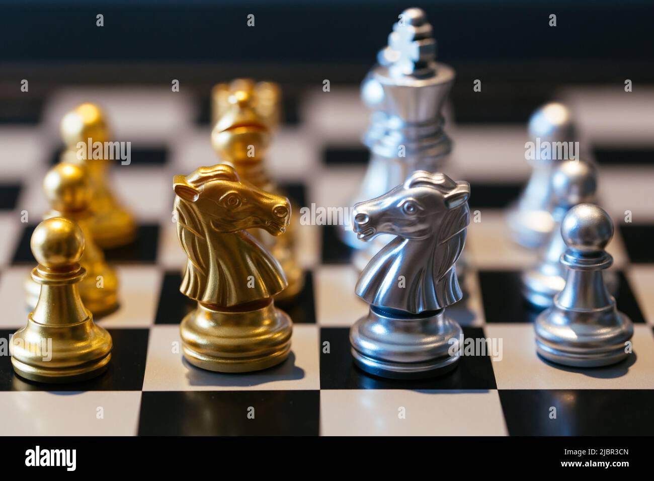 Closeup shot of chess knights placed on chessboard in front of each ...