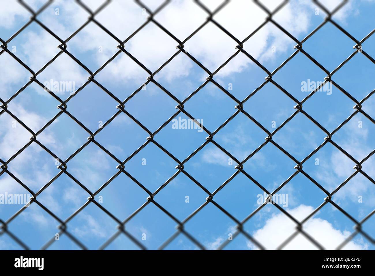 Metal wire fence on clear sky background Stock Photo - Alamy