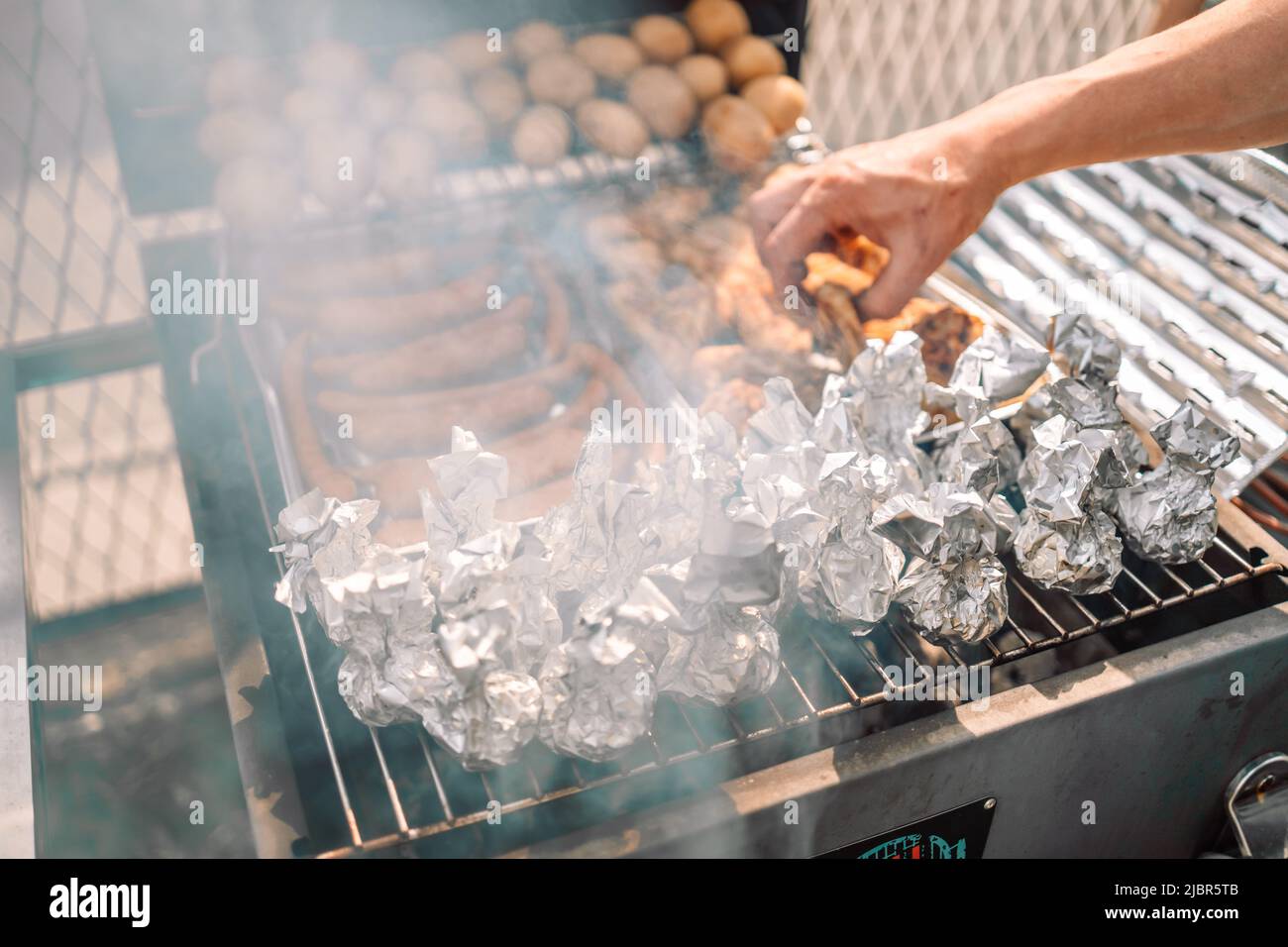 Close up view of men hands roasting barbecue on fire grill Stock Photo ...