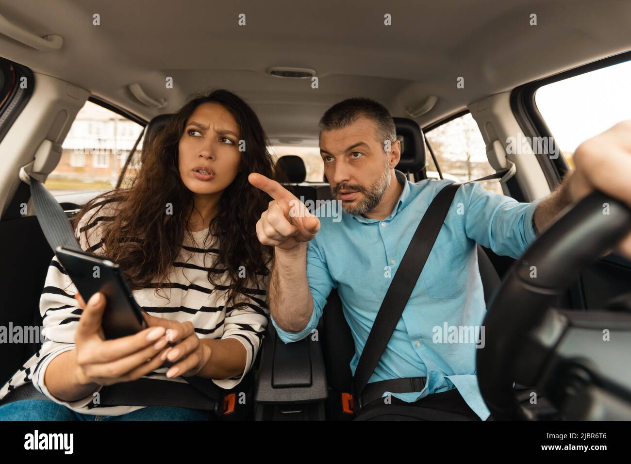 Couple Driving Using Cellphone Sitting In New Automobile Stock Photo ...