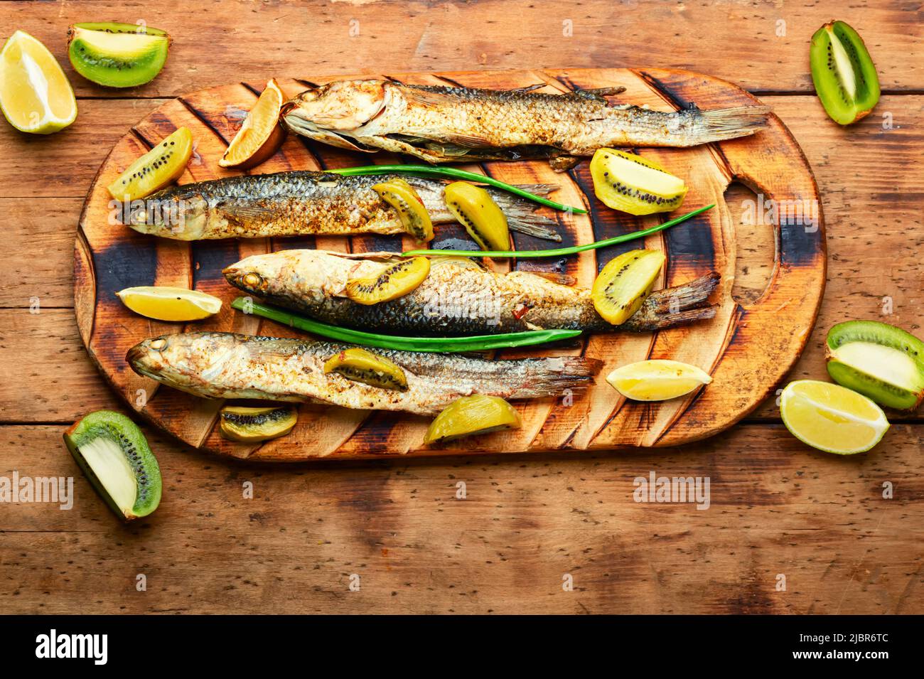 Tasty roast pelengas, fish with kiwi and lime Stock Photo - Alamy