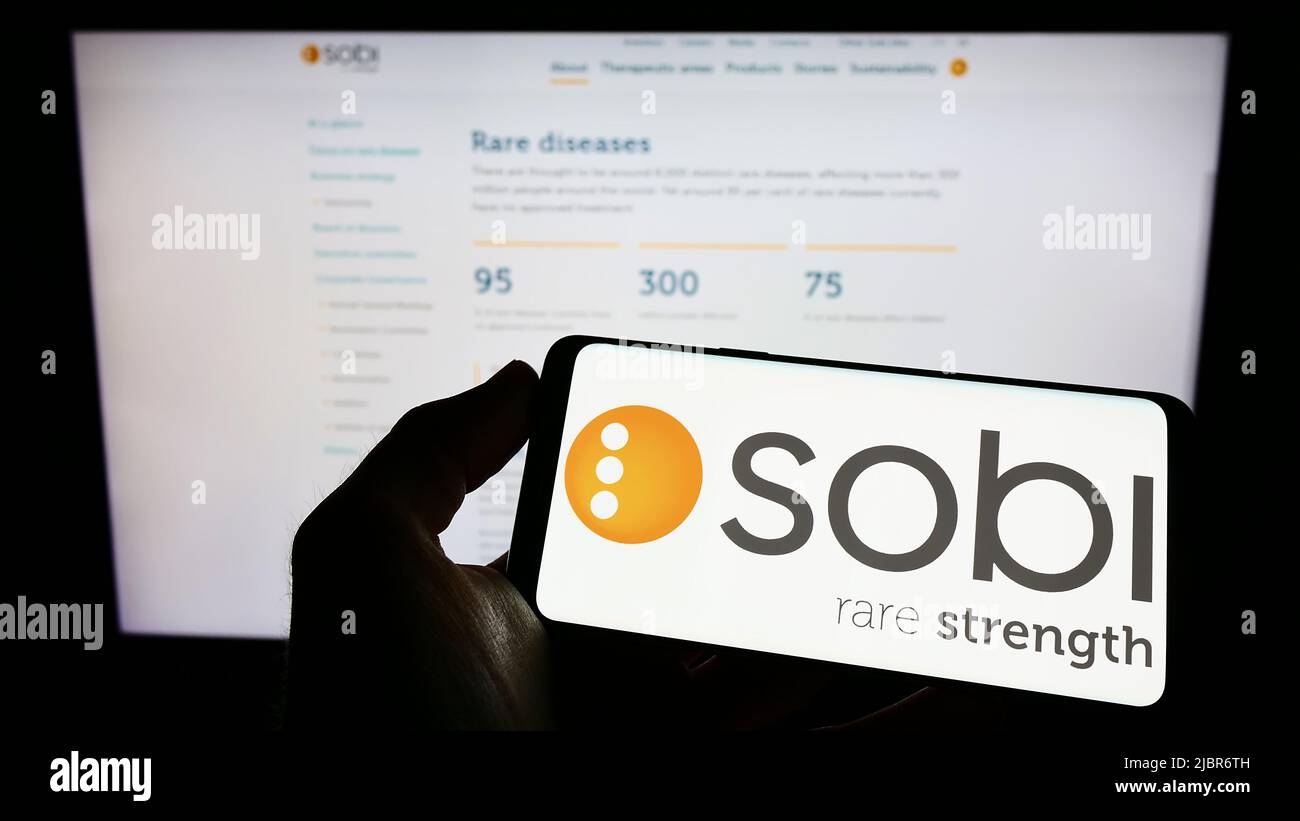 Person holding cellphone with logo of company Swedish Orphan Biovitrum ...