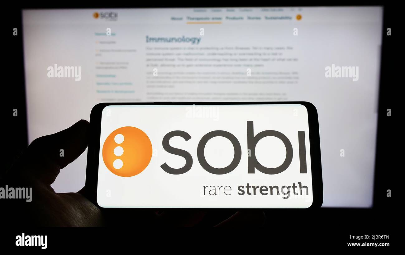 Person holding smartphone with logo of company Swedish Orphan Biovitrum ...