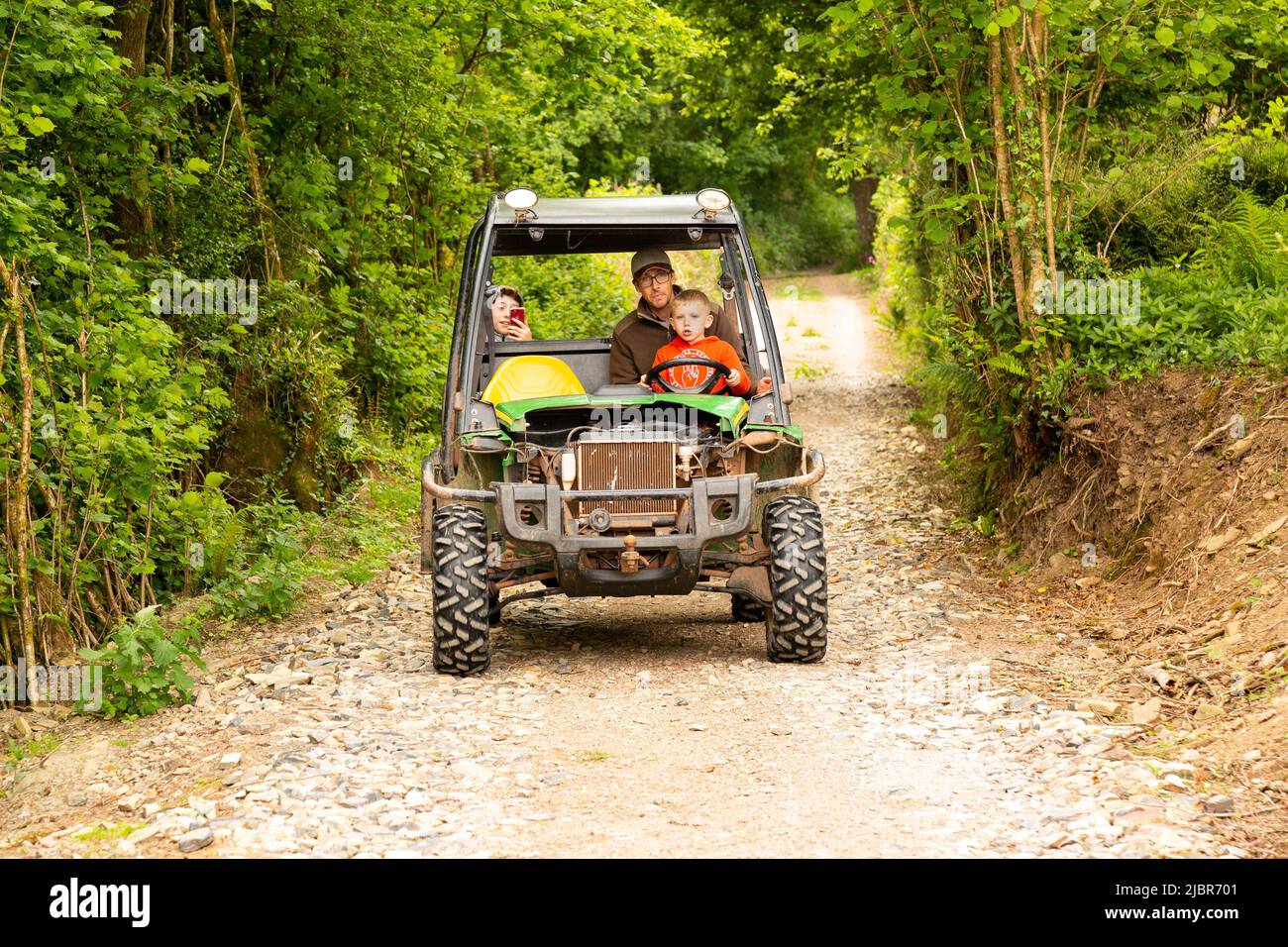 Boys riding in a John Deere gator utility vehicle, High Bickington ...