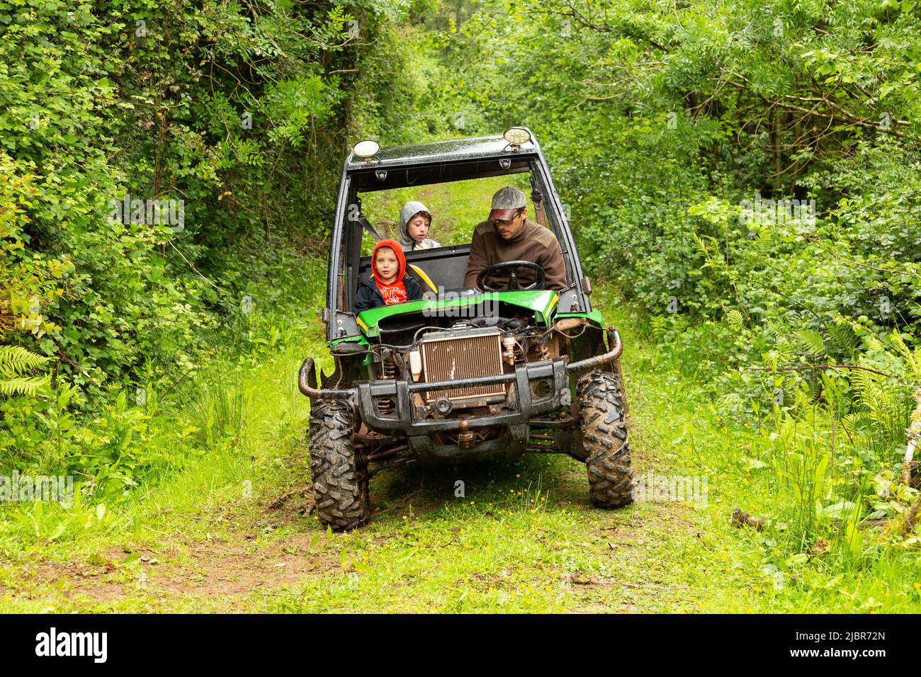 Boys riding in a John Deere gator utility vehicle, High Bickington ...