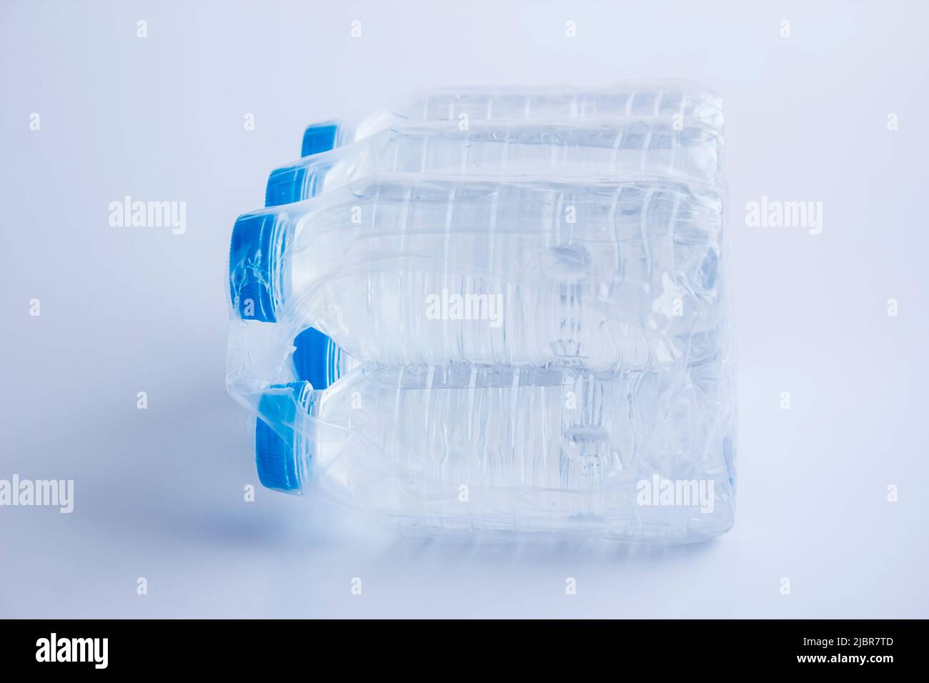 Six small pet bottles of natural spring water in transparent packing ...