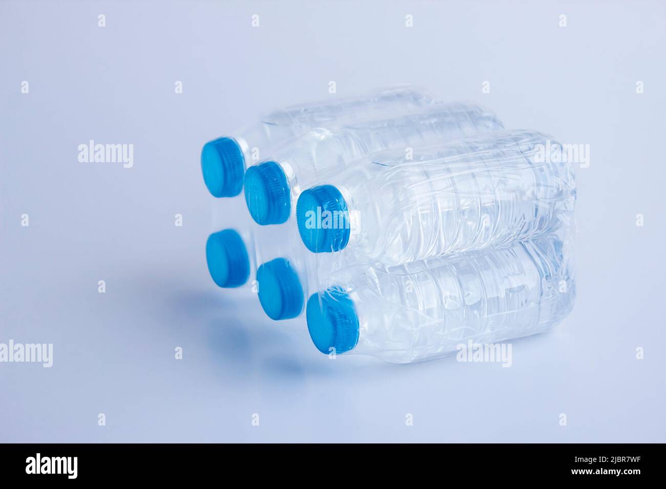 Six small pet bottles of natural spring water in transparent packing ...