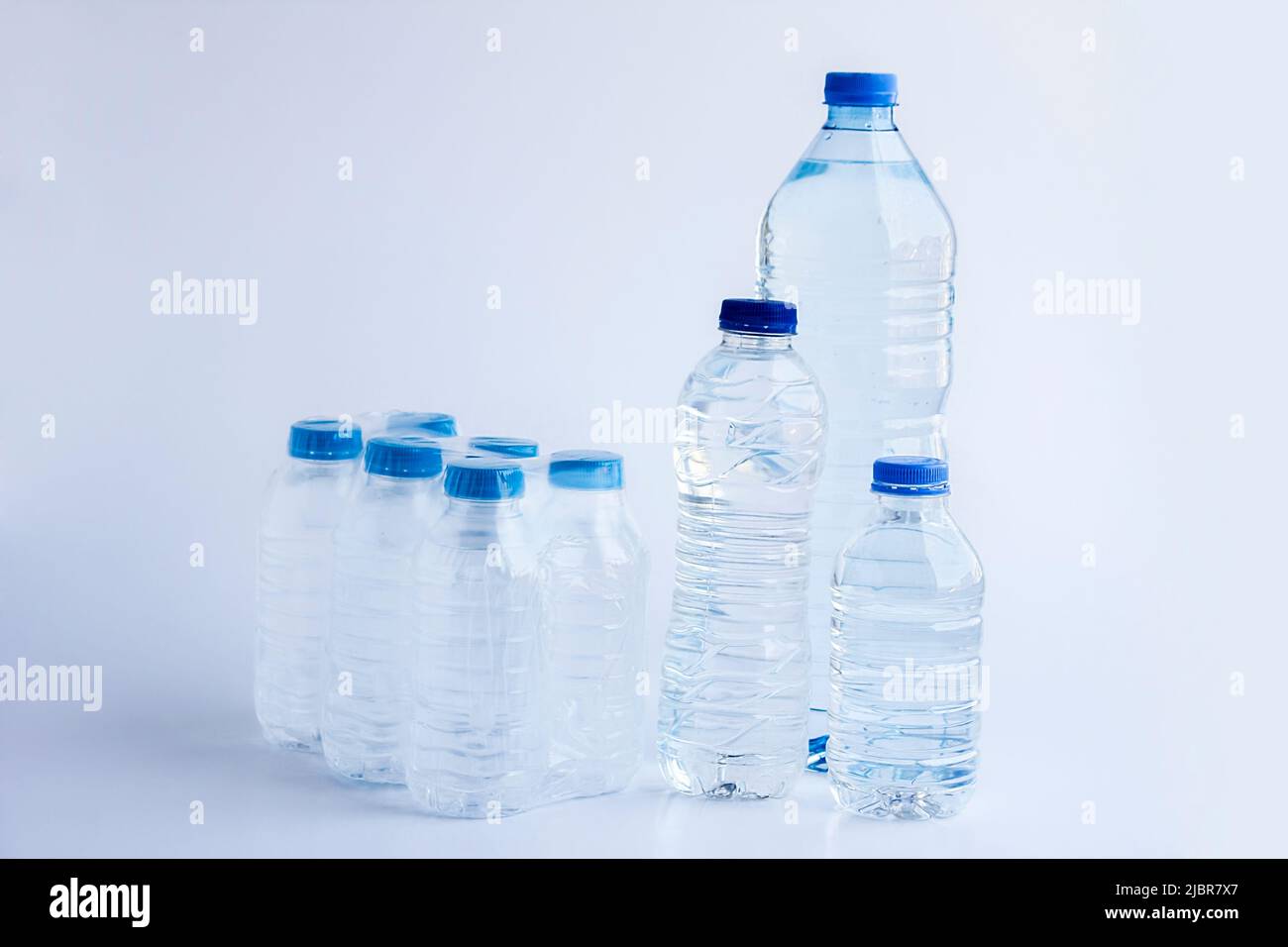 Different size plastic bottles of natural spring water on the white ...