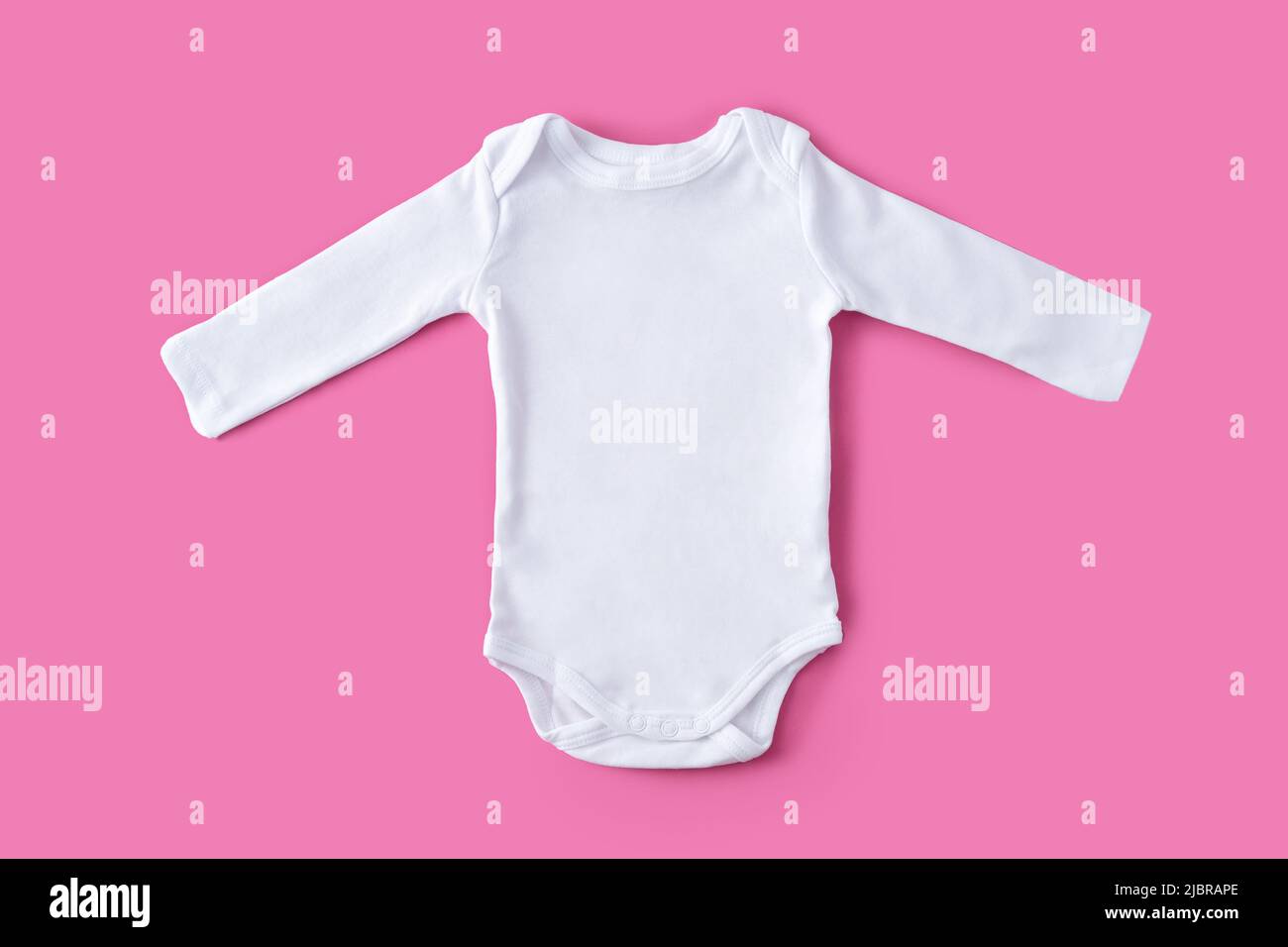 White baby clothes on pink background Stock Photo - Alamy