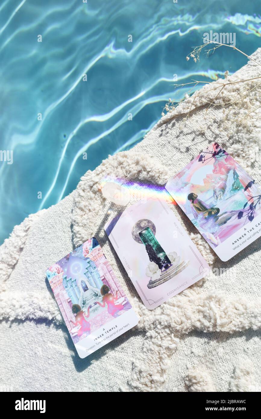 Oracle cards and clear quartz crystal on poolside bohemian picnic rug ...